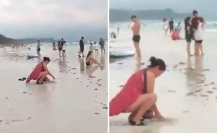 Turistas palaidojo purviną vystyklą smėlio paplūdimyje Filipinuose.